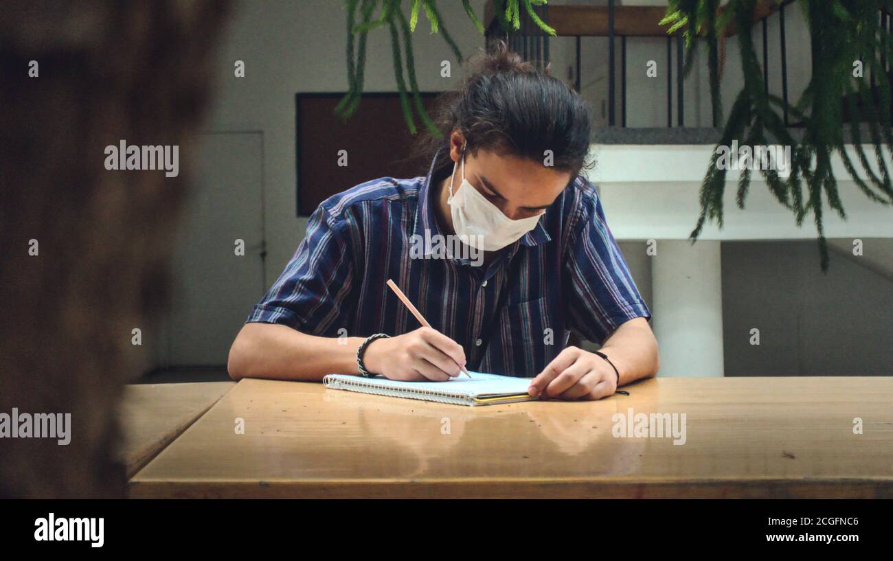 Front view Isolated long haired and masked young university student ...