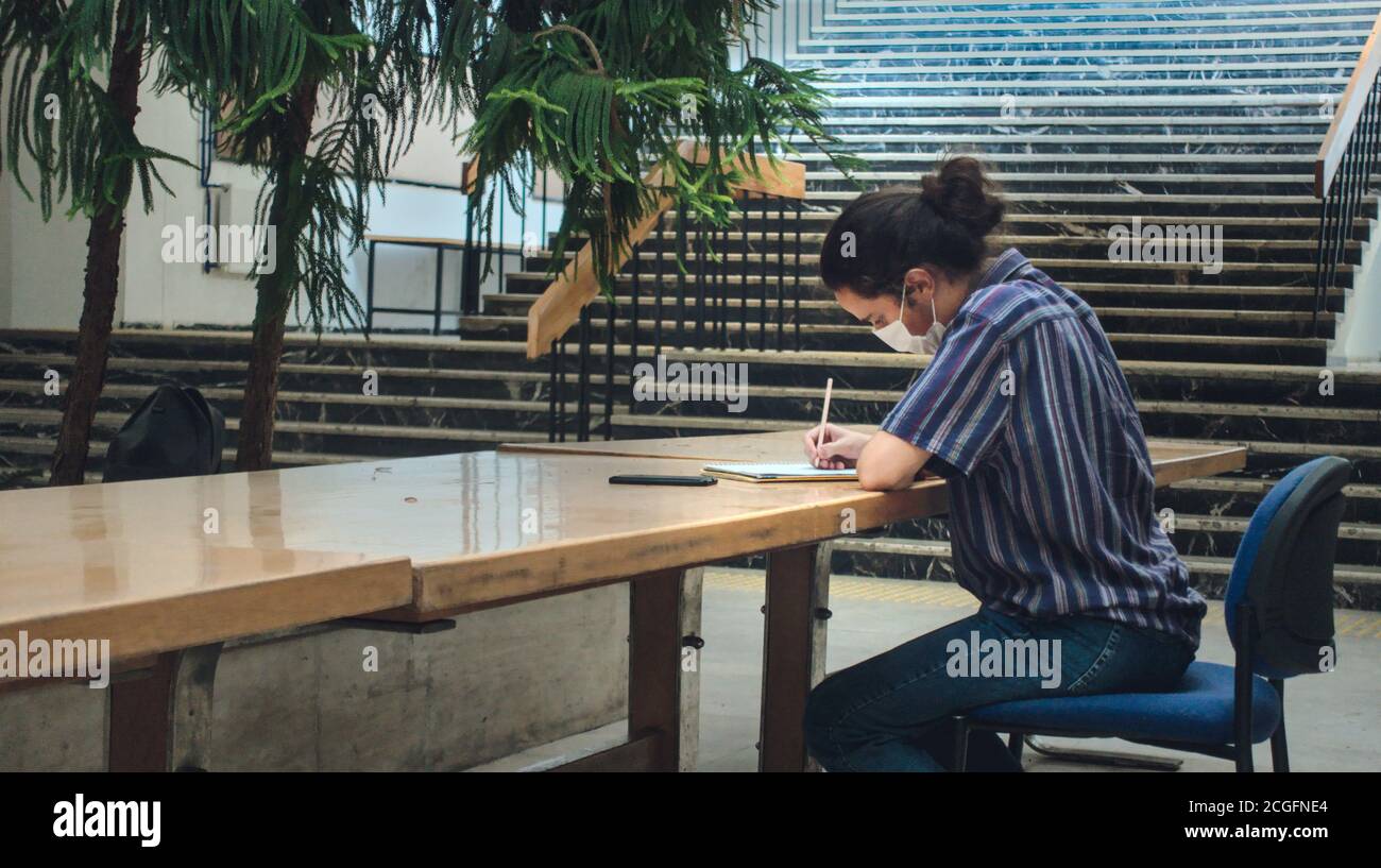 Left angle Isolated long haired and masked young university student ...