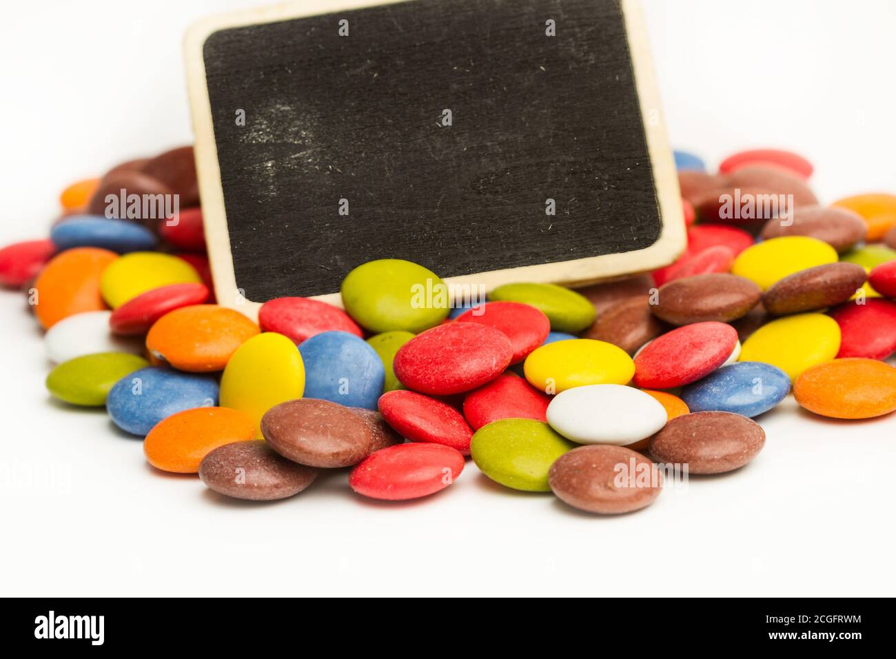 Multicolored hard shell chocolate candies with a blank small blackboard ...