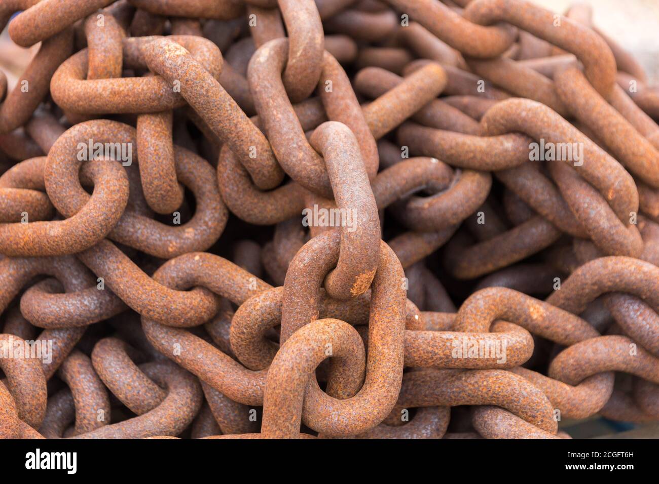 A long rusty chain heaped into a pile Stock Photo - Alamy