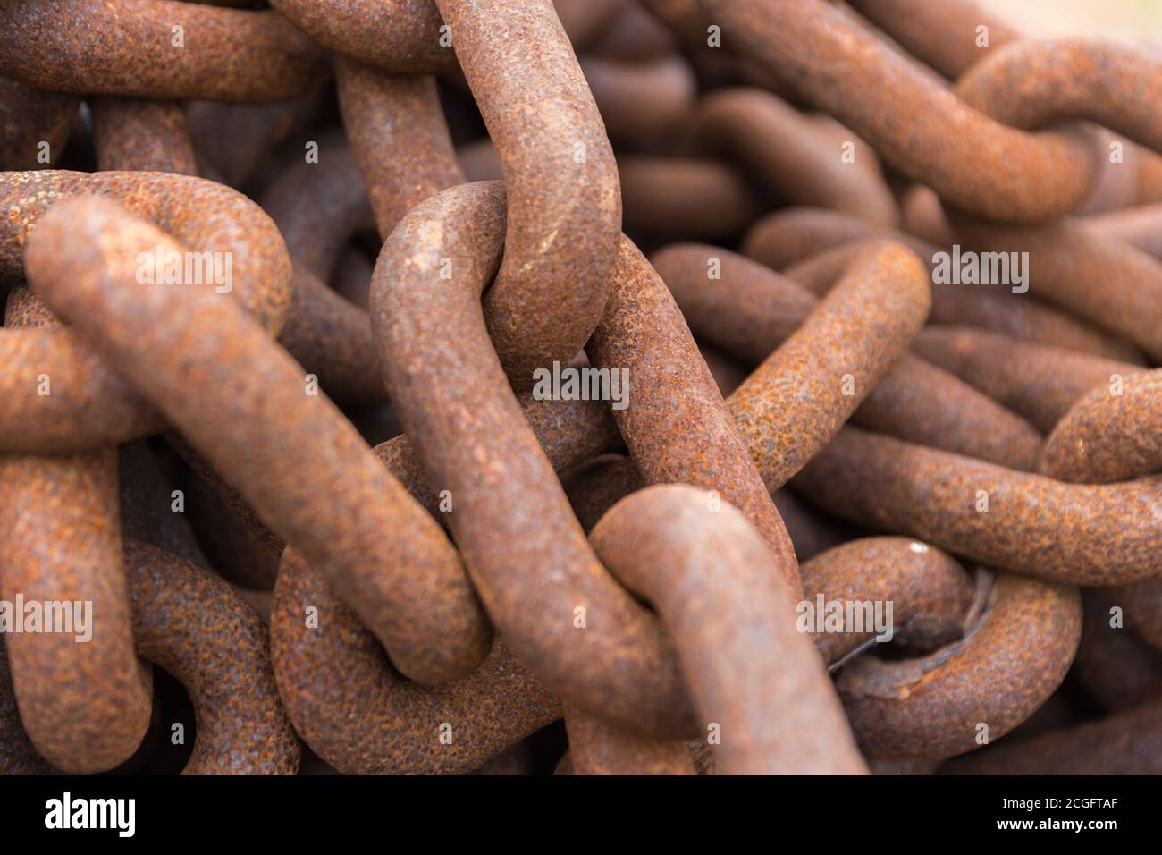 A long rusty chain heaped into a pile Stock Photo - Alamy