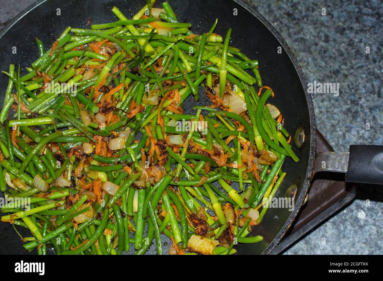 Fried string beans with onions and carrots in a dark pan Stock Photo ...