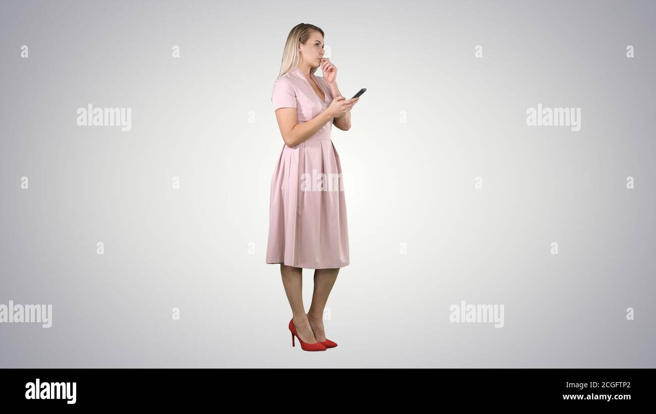 Blonde teenager woman wearing pink texting message on her smartphone on ...