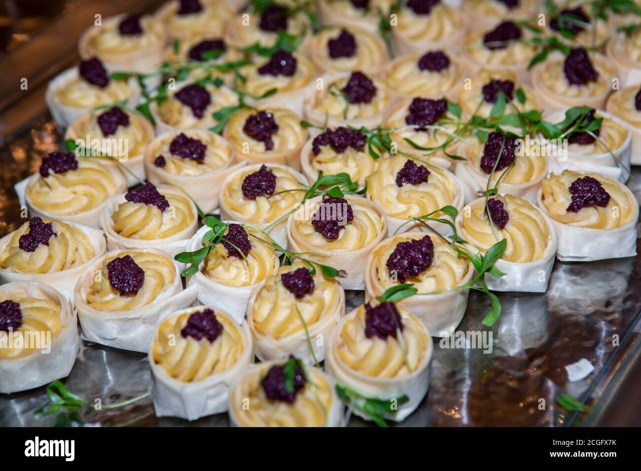 Trestle tables with plates full of buffet food being made ready at a ...