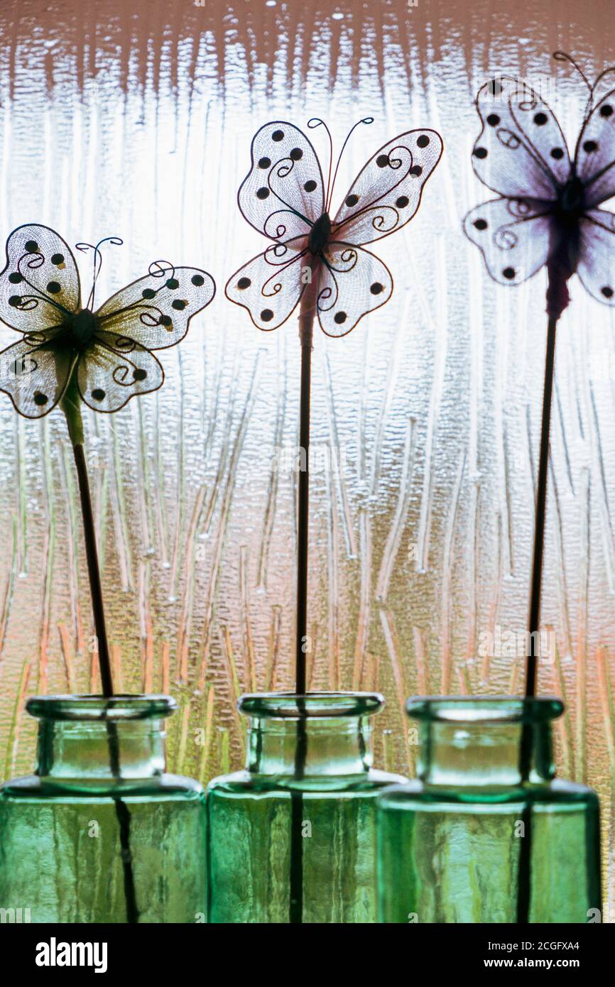 Threee delicate butterflies made from wire and material on sticks ...