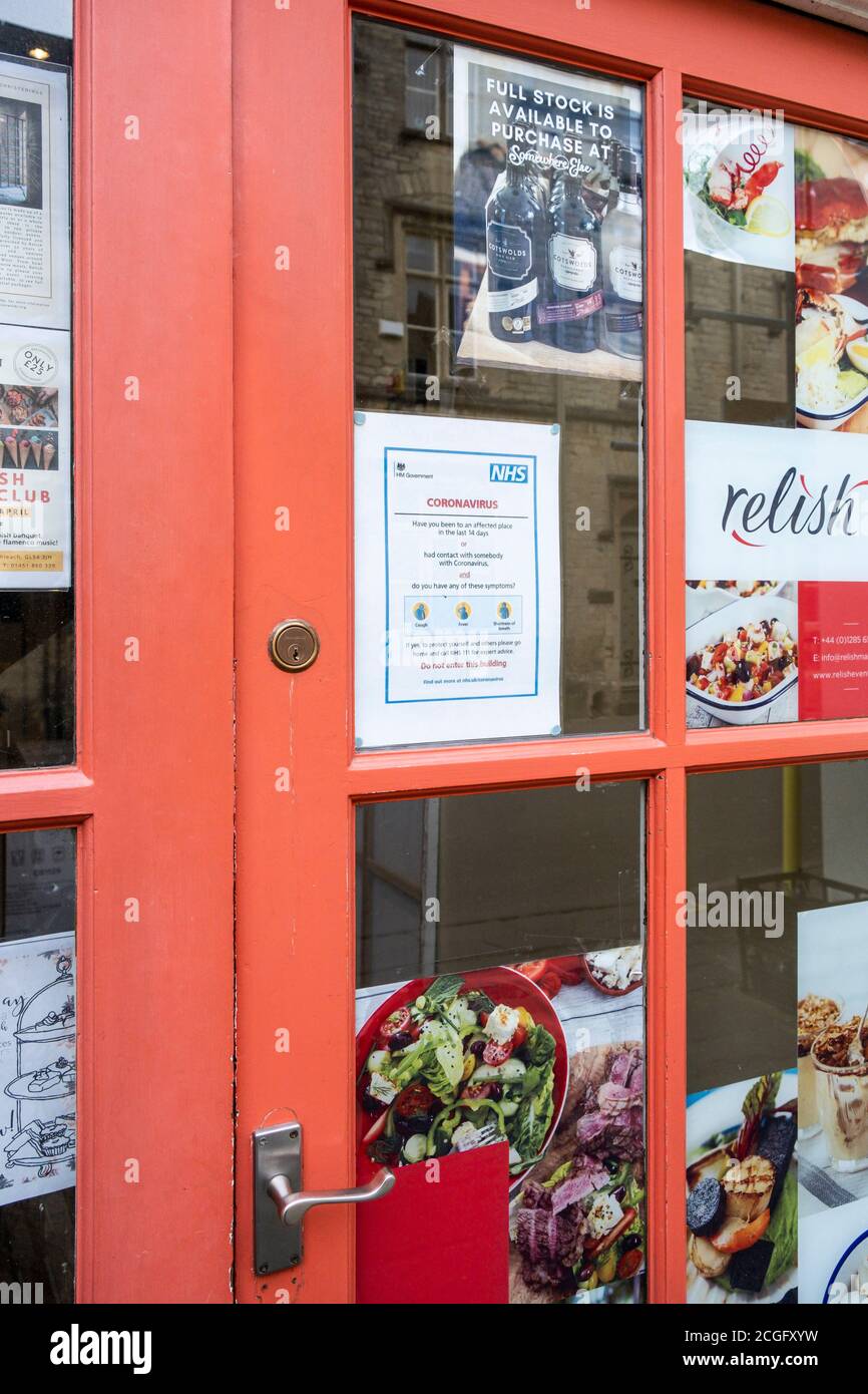 Shop windows in the town of Cirencester with various notices to the ...