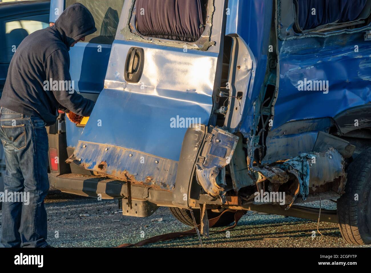 A rumpled blue minibus is on the road after an accident. Accident on ...