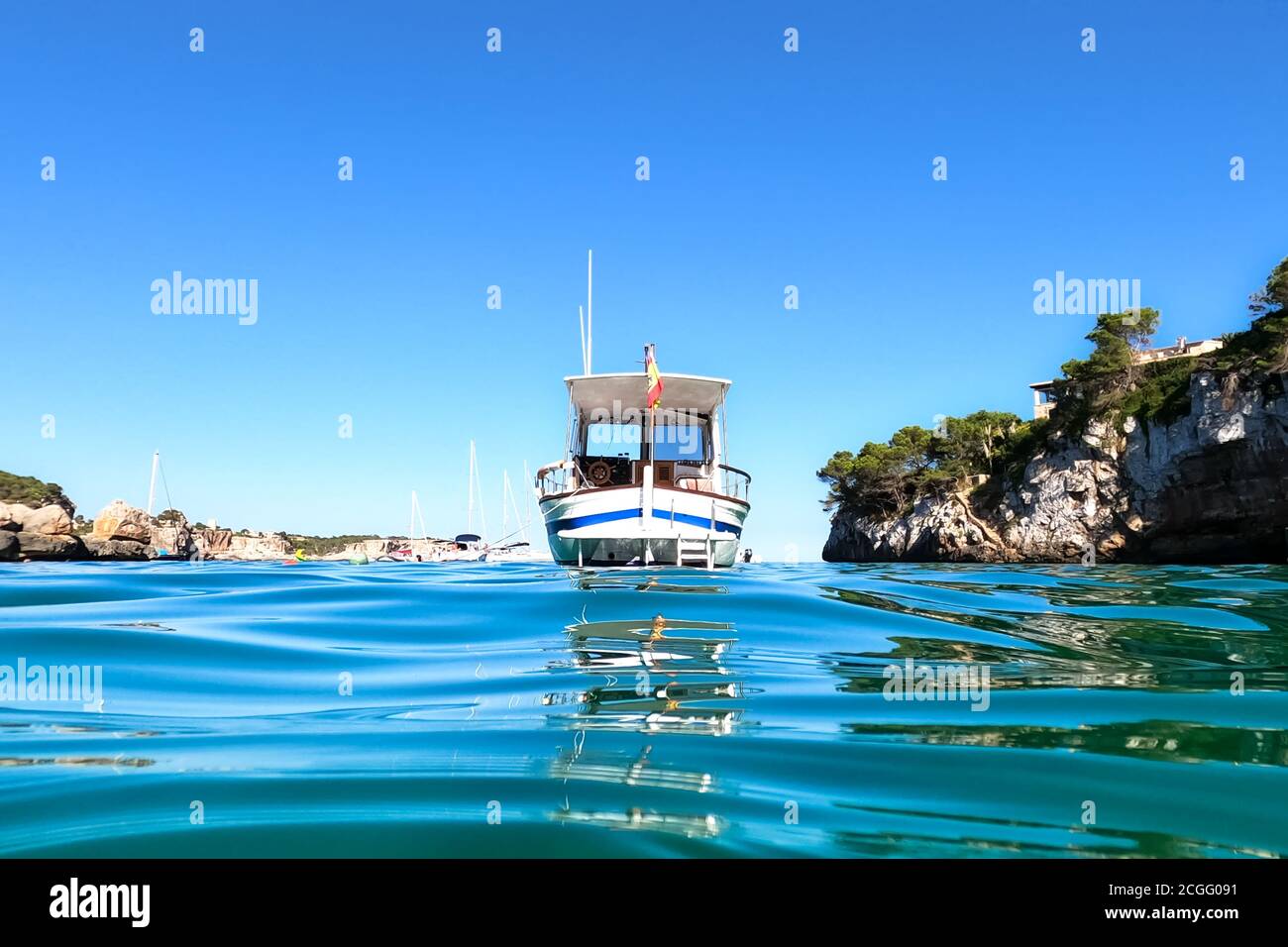 Rear view of an isolated boat without people anchored in a cove in ...