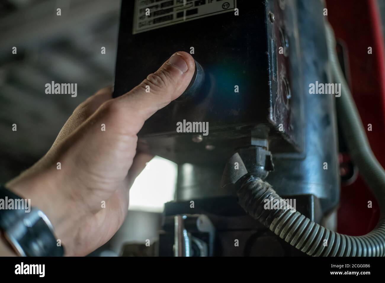 Male hand close-up presses the lift button in the industrial premises ...