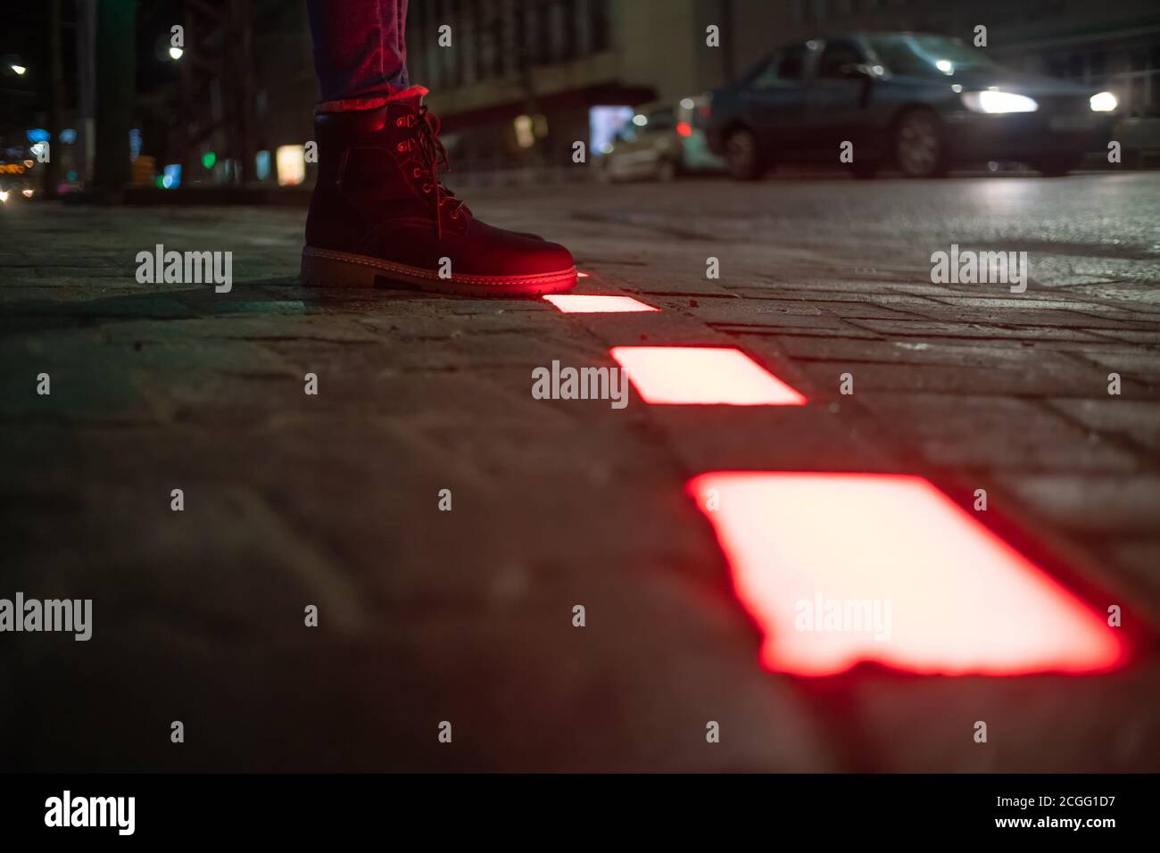 girl's feet in boots are standing on a pedestrian crossing and waiting ...