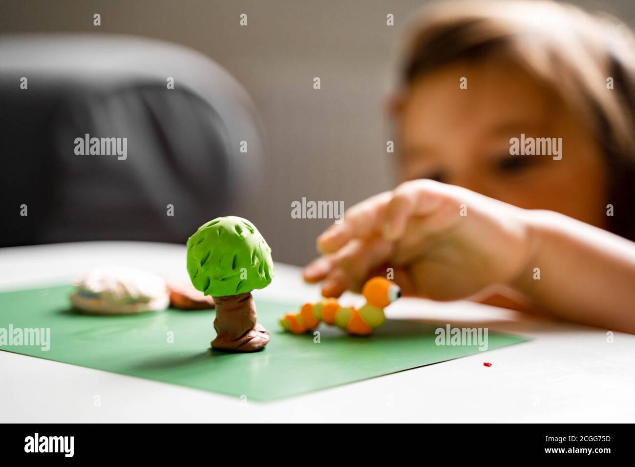 Caucasian toddler girl playing modeling play dough at home with mother ...