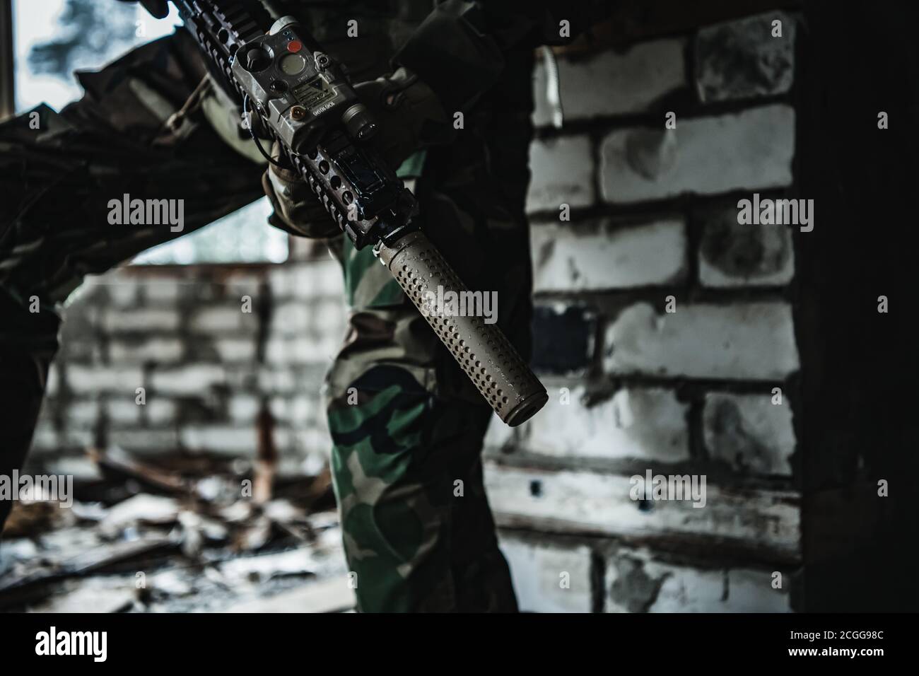Weapons close-up on a military man standing inside the building and ...