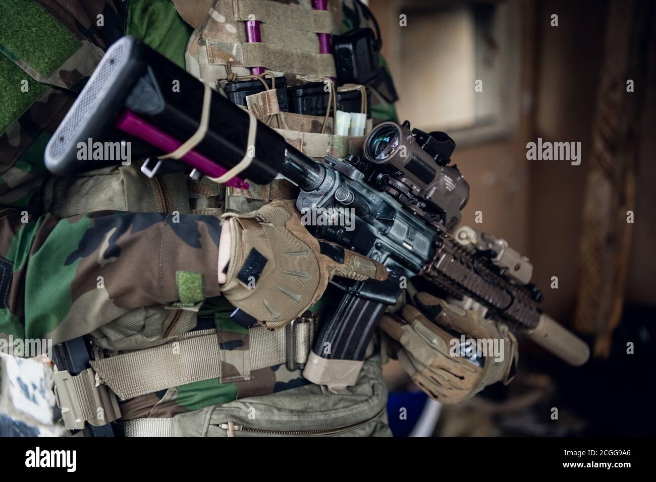 Weapons close-up on a military man standing inside the building and ...
