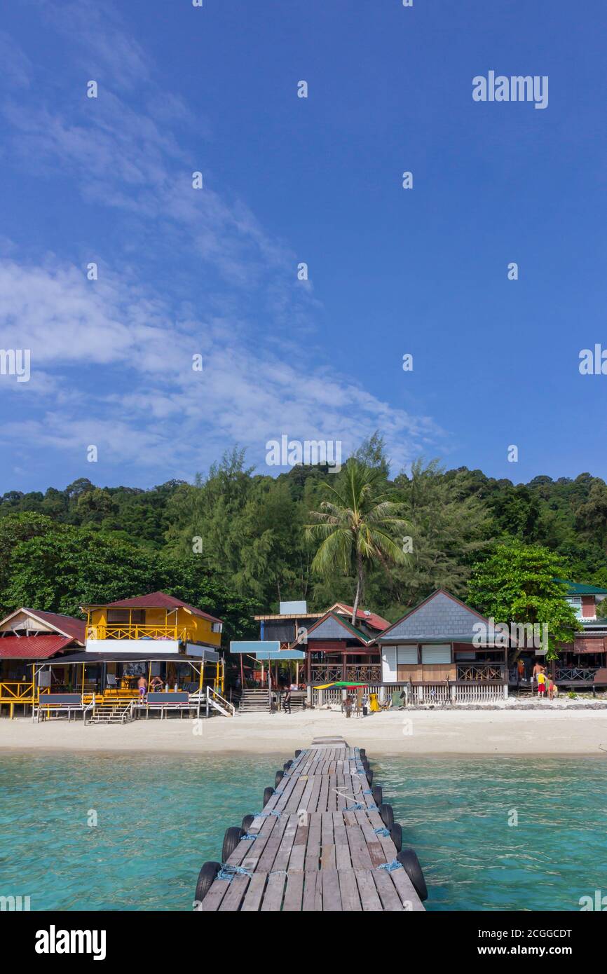 Jetty view on the island village under a pur blue sky and purple water ...