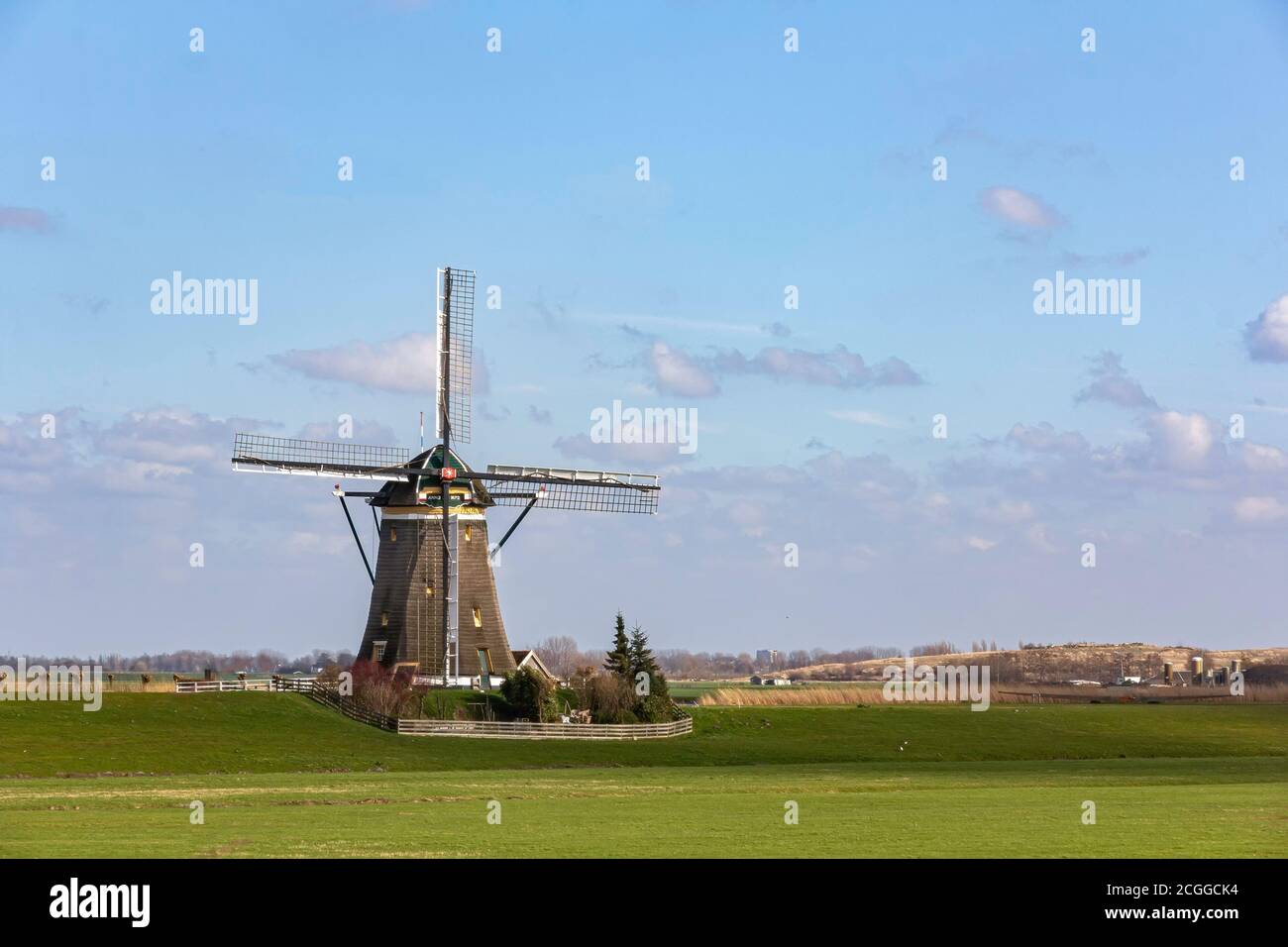 Dutch windmill at the edge of the wet land located under the sea level ...