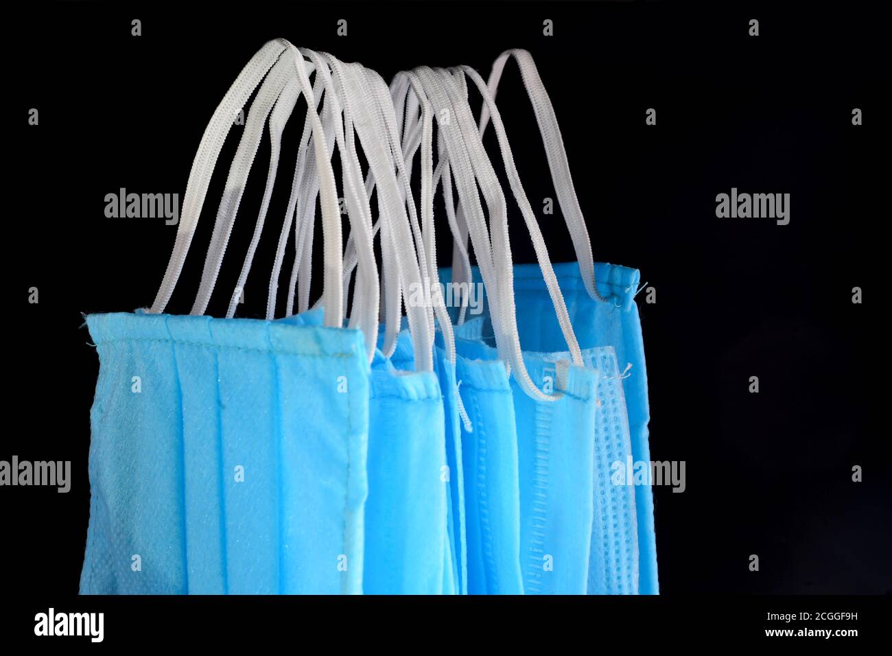 Hanging blue surgical mask separated in black backdrop Stock Photo - Alamy