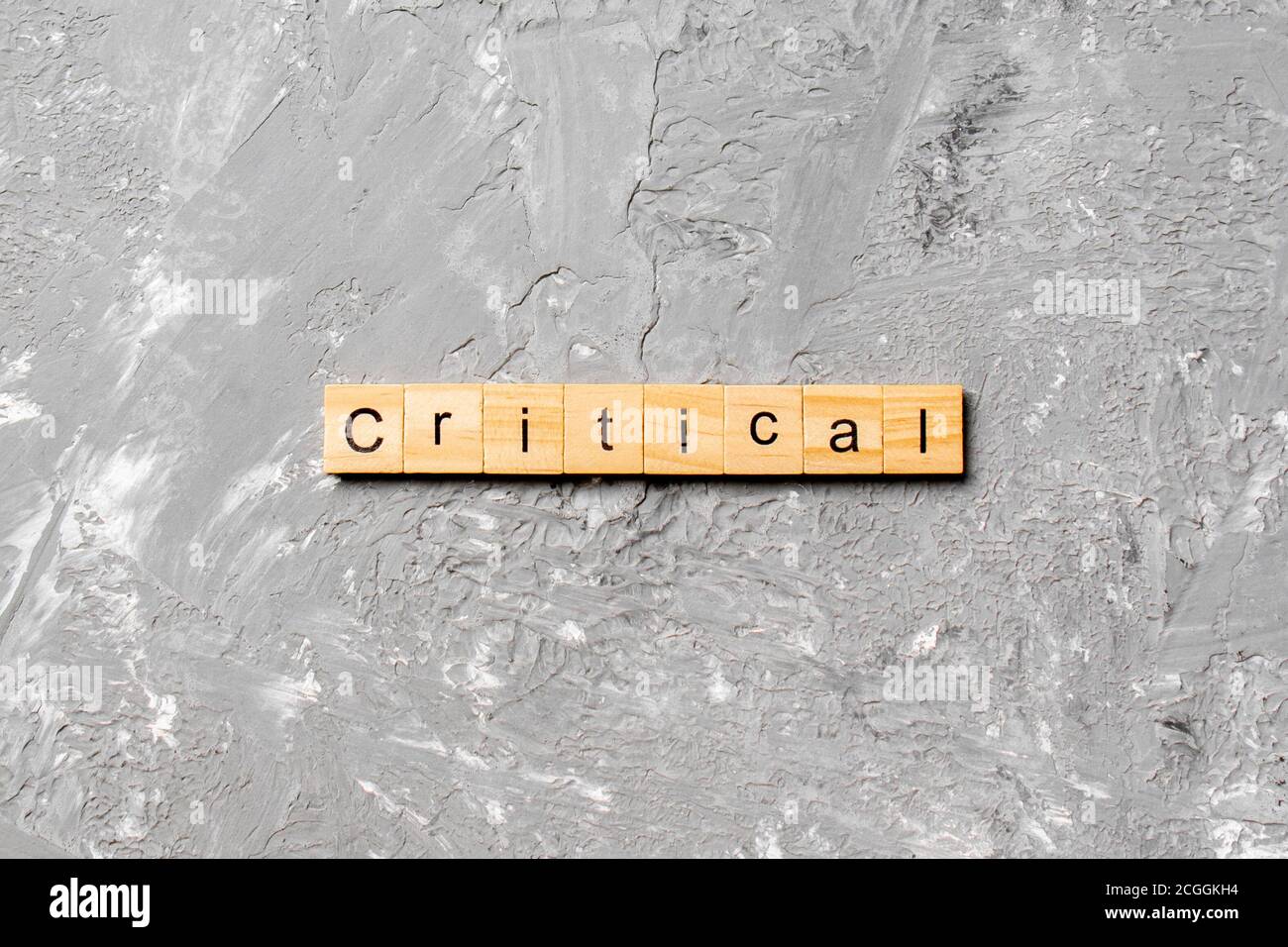 critical word written on wood block. critical text on table, concept ...