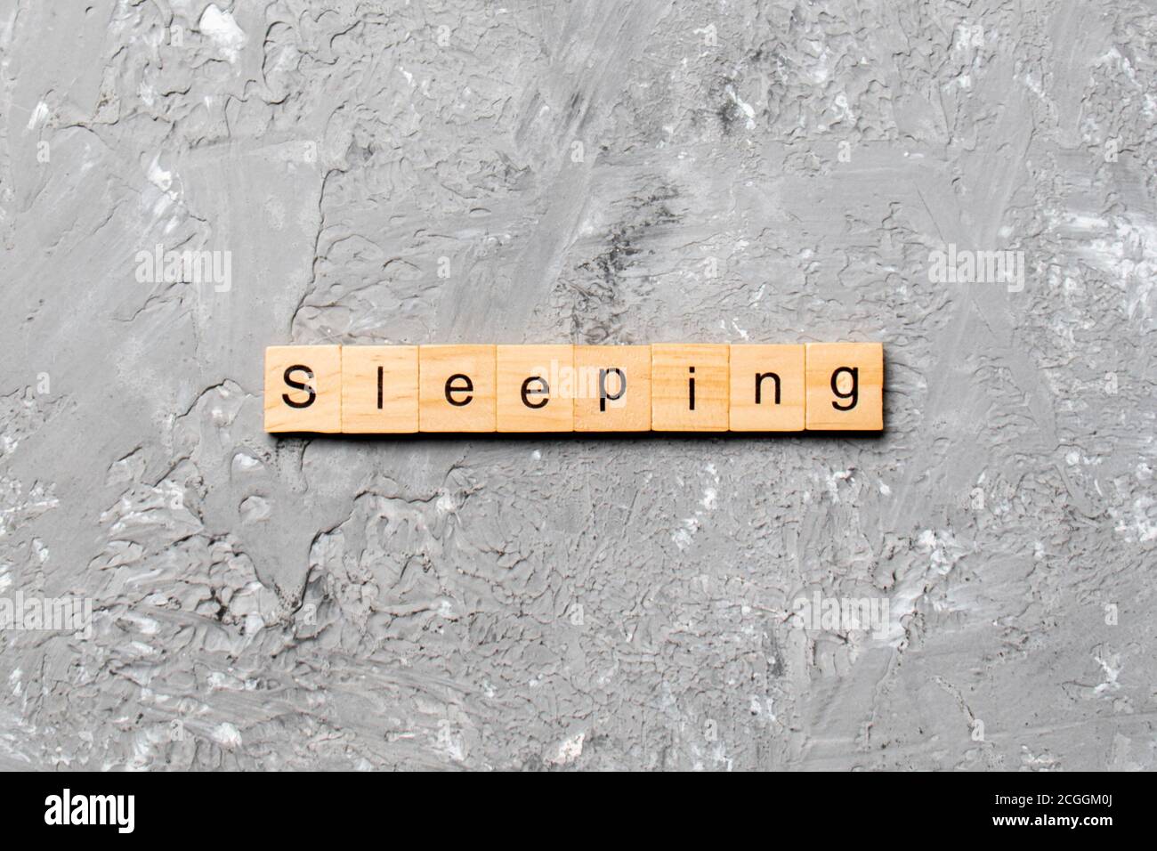 SLEEPING word written on wood block. SLEEPING text on cement table for ...