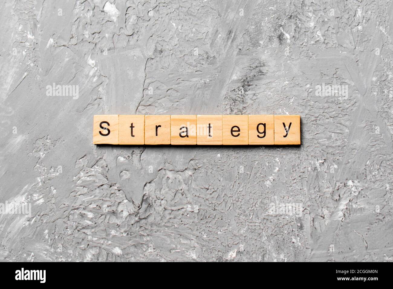STRATEGY word written on wood block. STRATEGY text on cement table for ...