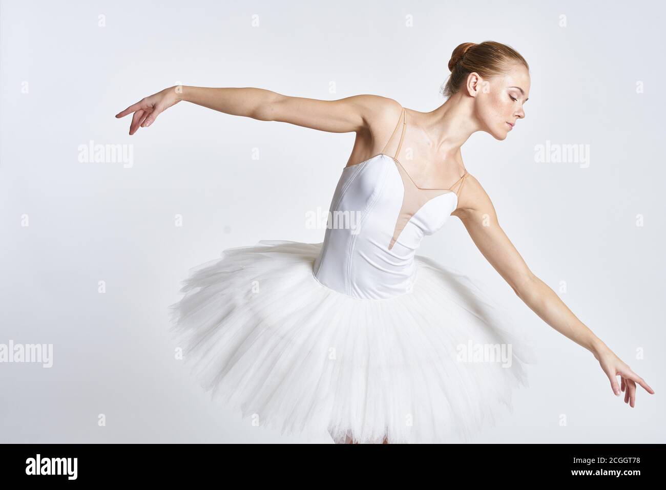 Ballerina in a white tutu dance performed on a light background Stock ...
