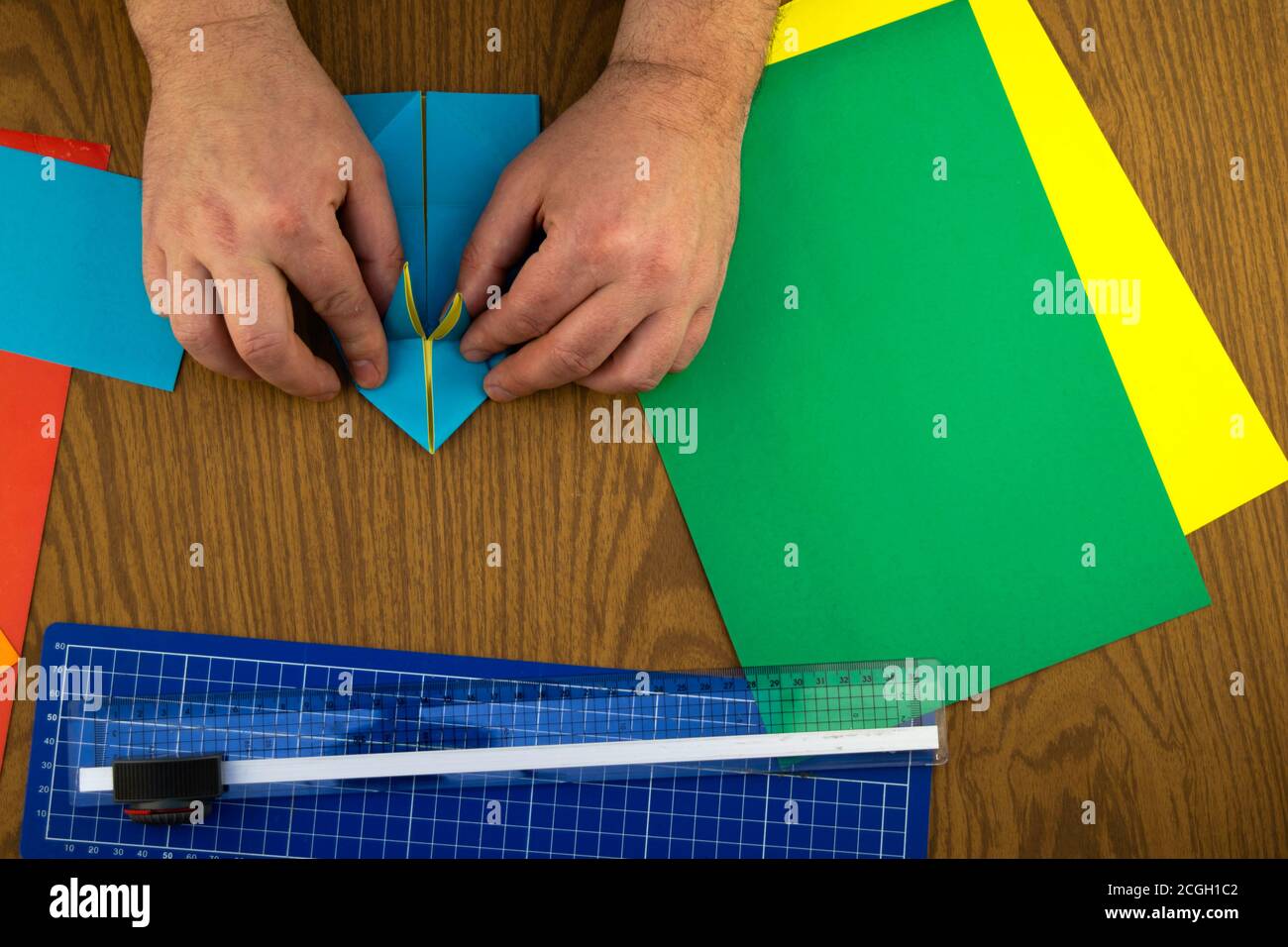 a paper bunny for Easter, hands make origami from colored paper ...