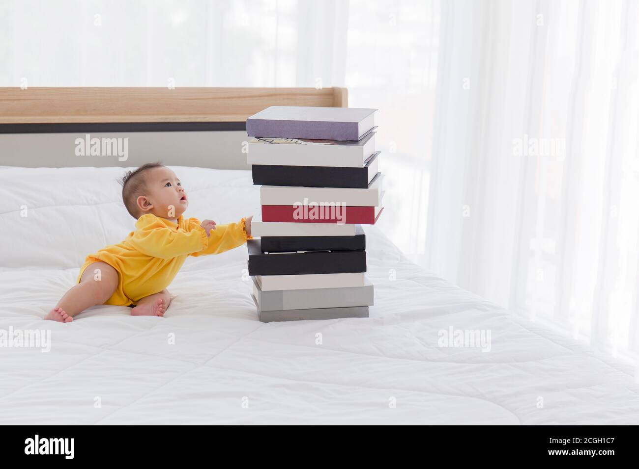 Baby girl sitting on pile hi-res stock photography and images - Alamy