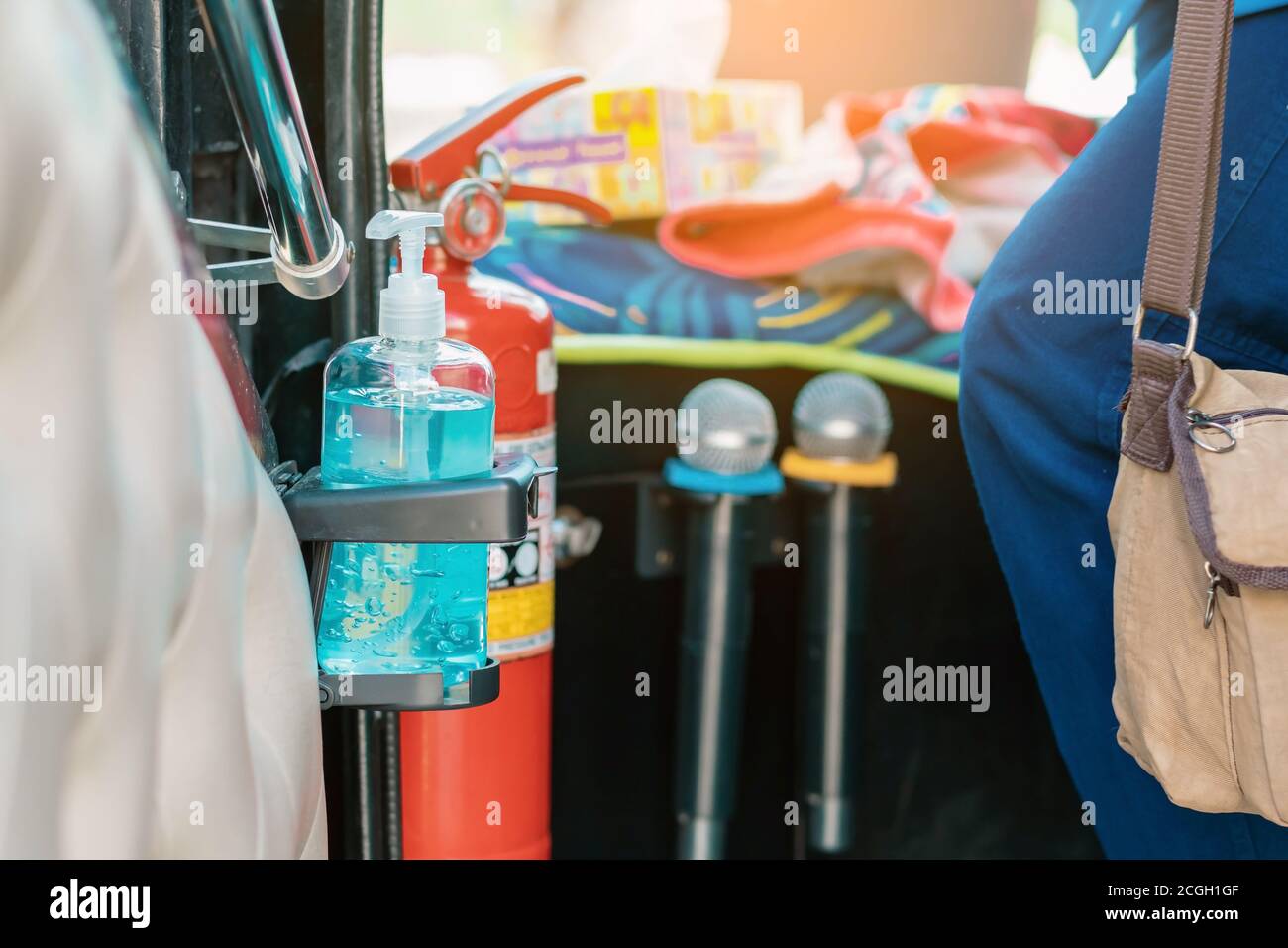 Blue alcohol gel bottle hanging on the door of the double-decker bus to ...