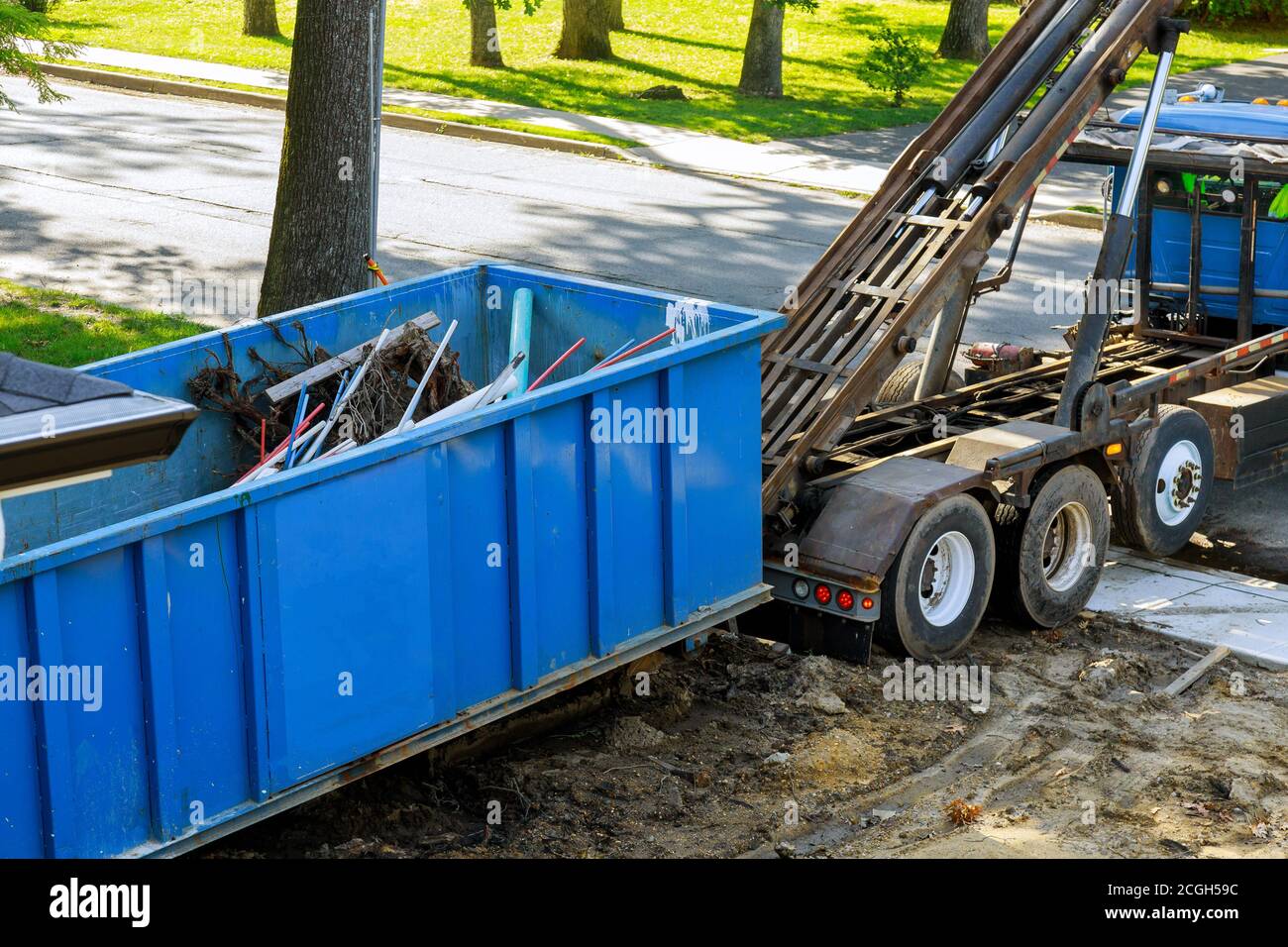 Metal trash container loading the garbage can waste construction trash ...