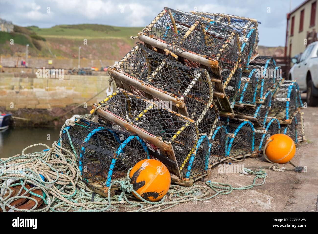 Lobster pots on a quay side waiting to be loaded onto a fishing boat ...