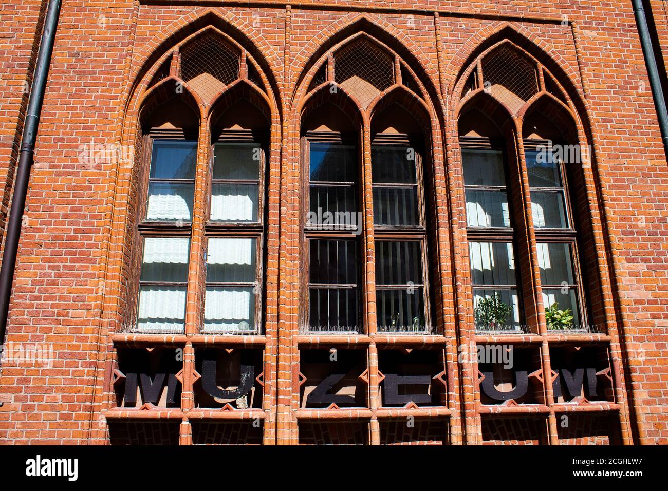 Three Gothic windows side by side in a brick facade Stock Photo - Alamy