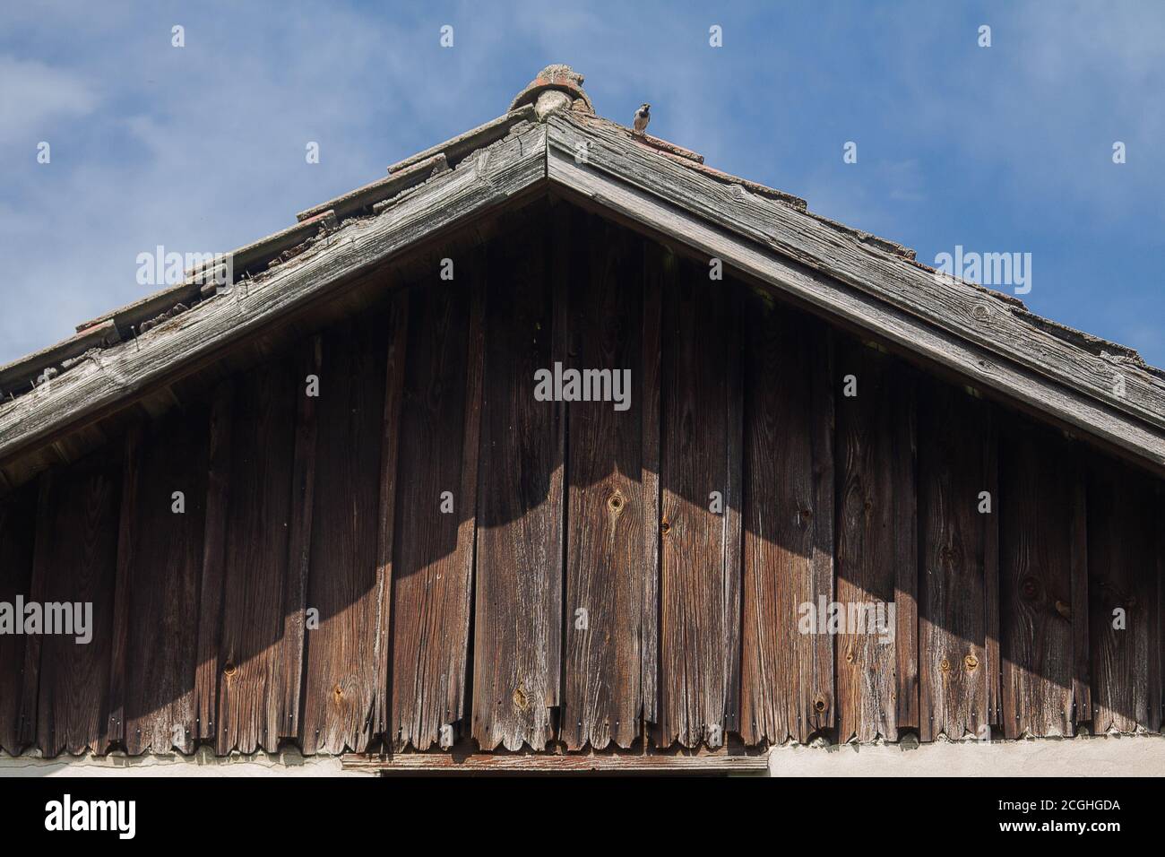 Wood-clad house gable. The roof is marked by the forces of nature. You ...