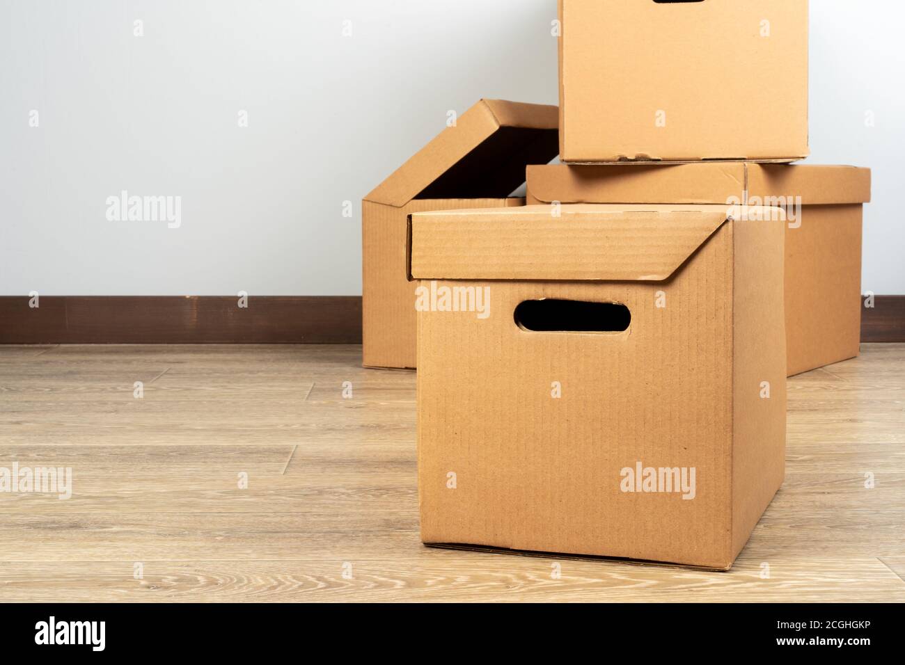 Group of brown carton boxes on wooden floor Stock Photo - Alamy