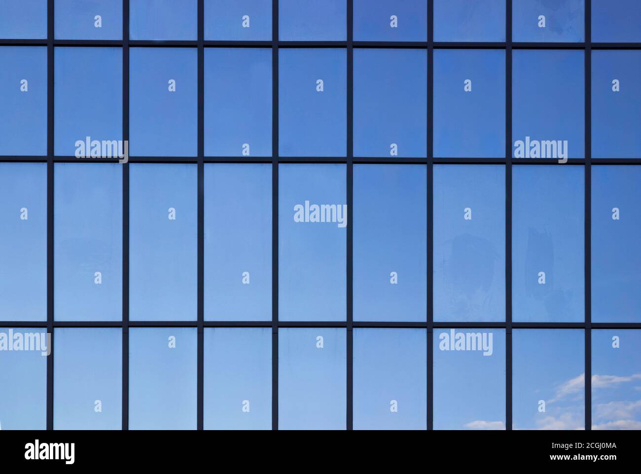 Windows in an office building, background. Blue sky reflected in the ...