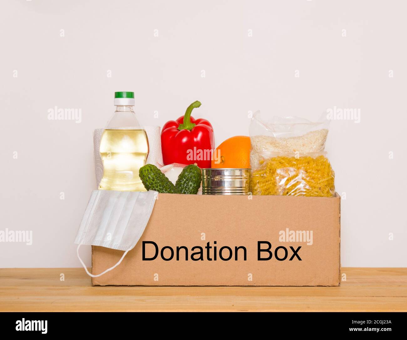 Donation box with various food. Open cardboard box with oil, canned ...