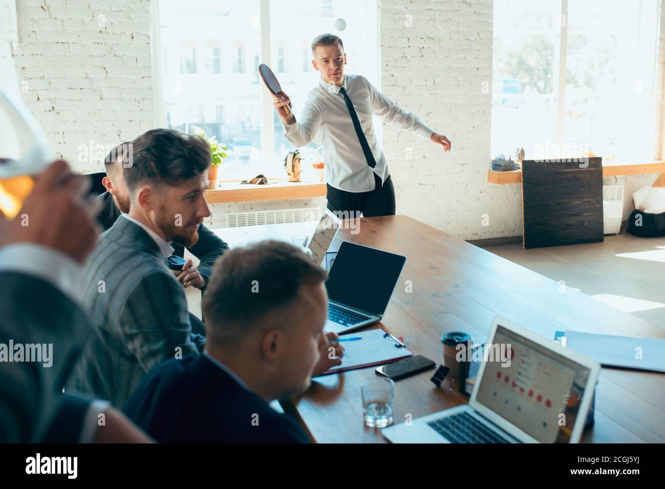 Playing table tennis, exciting. Happy carefree colleagues having fun in ...