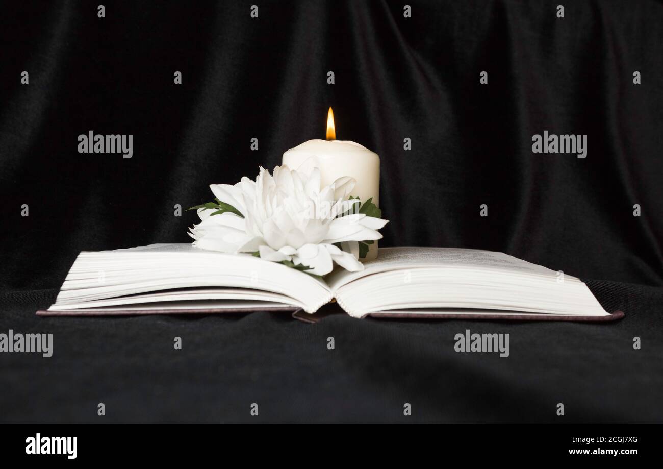 Condolence card. A white memorial candle with white flowers and an open ...