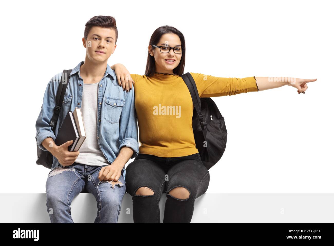 Students sitting on a panel and pointing to the side isolated on white ...