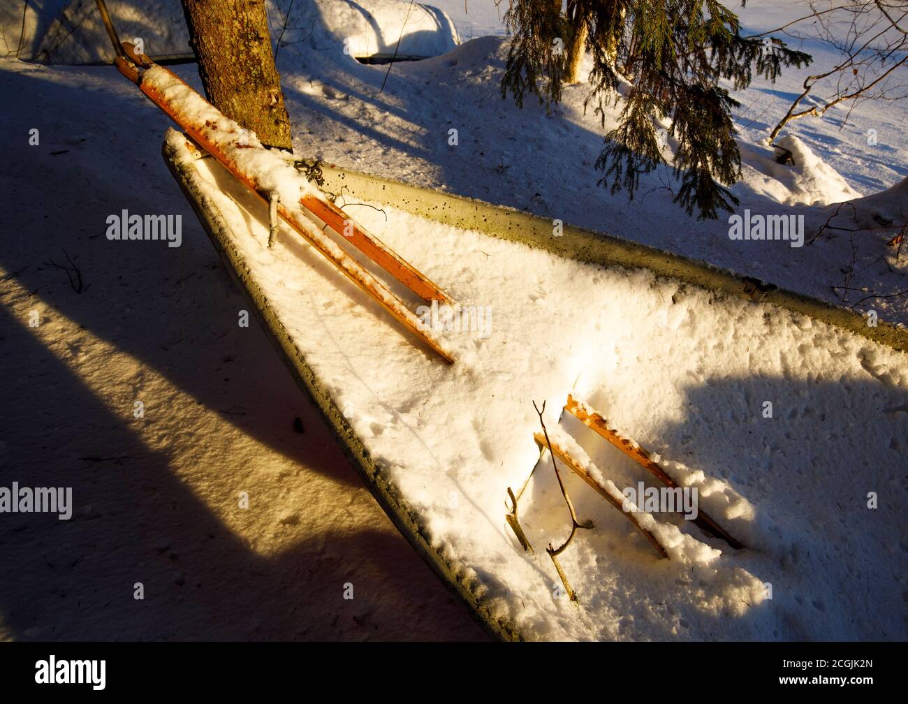 Pair of wooden oars and a rowing boat / skiff full of snow and ice at ...