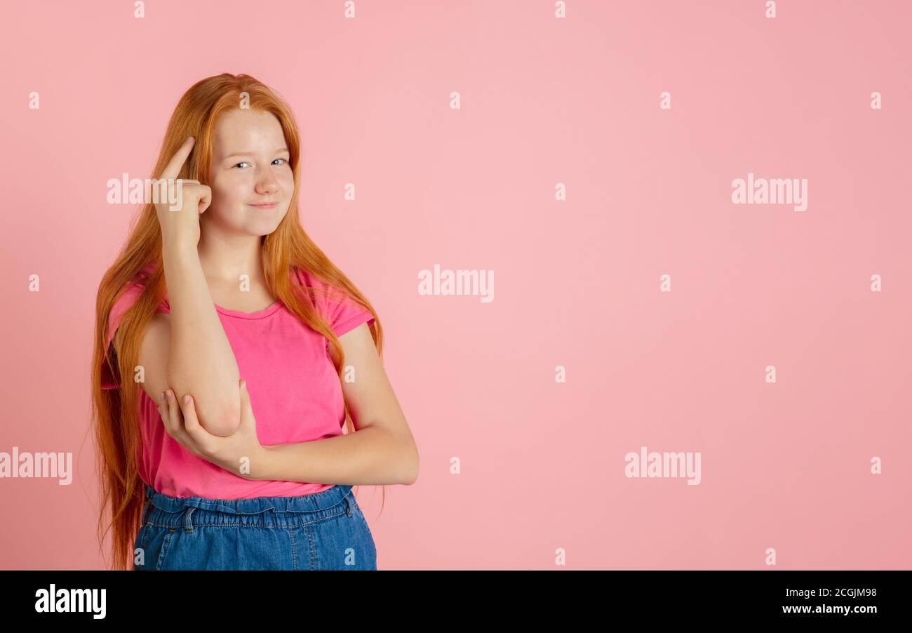 Smart thinking, irony. Caucasian teen girl's portrait on coral pink ...