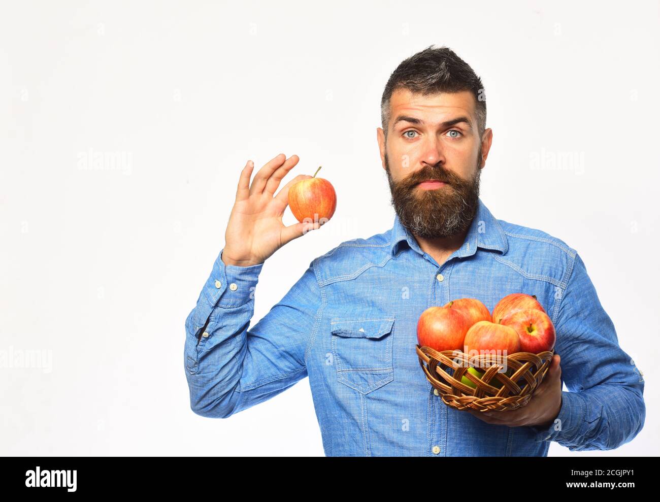 Farmer with surprised face holds red apples. Guy presents homegrown ...