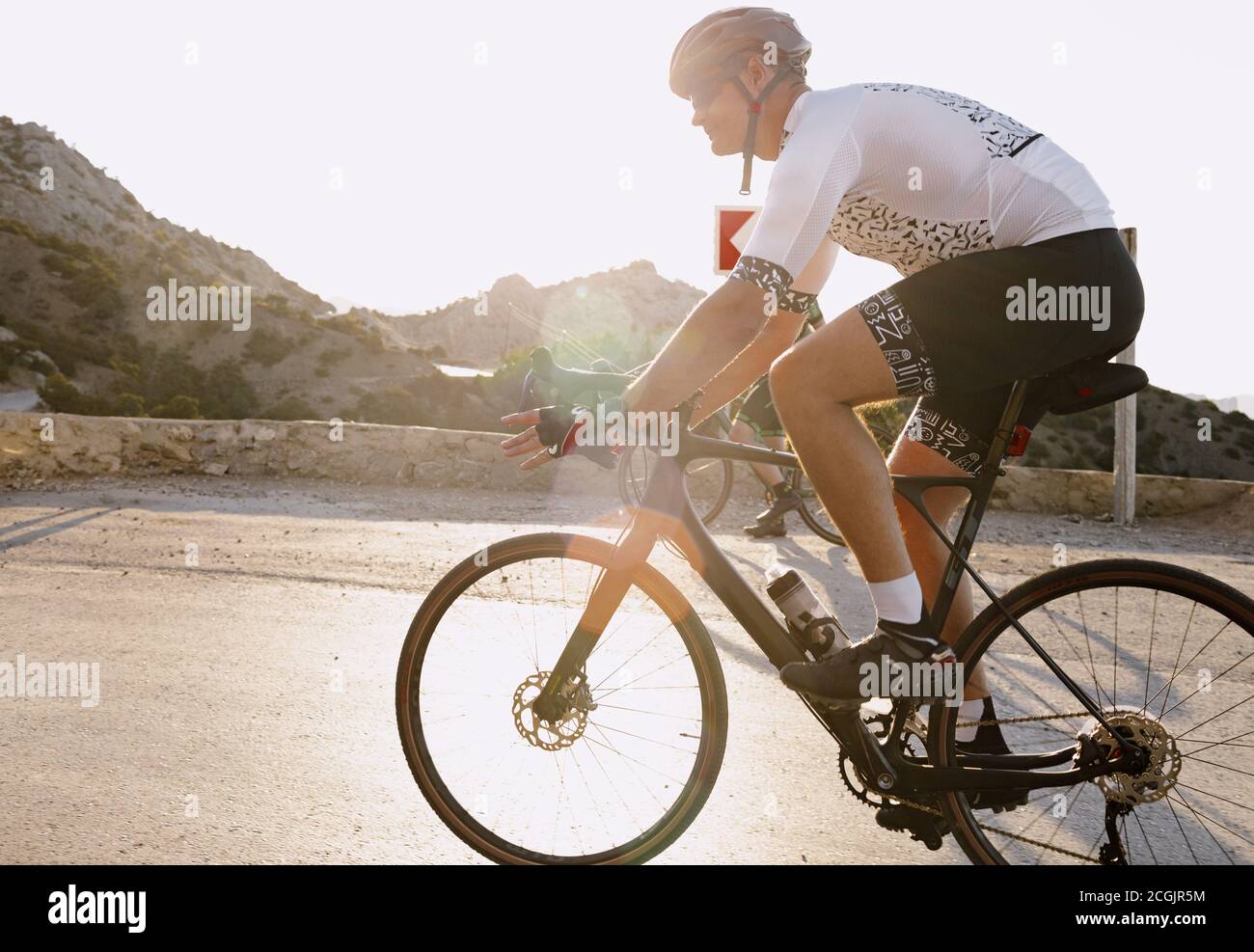 Professional road bicycle racer in action on mountain road Stock Photo ...