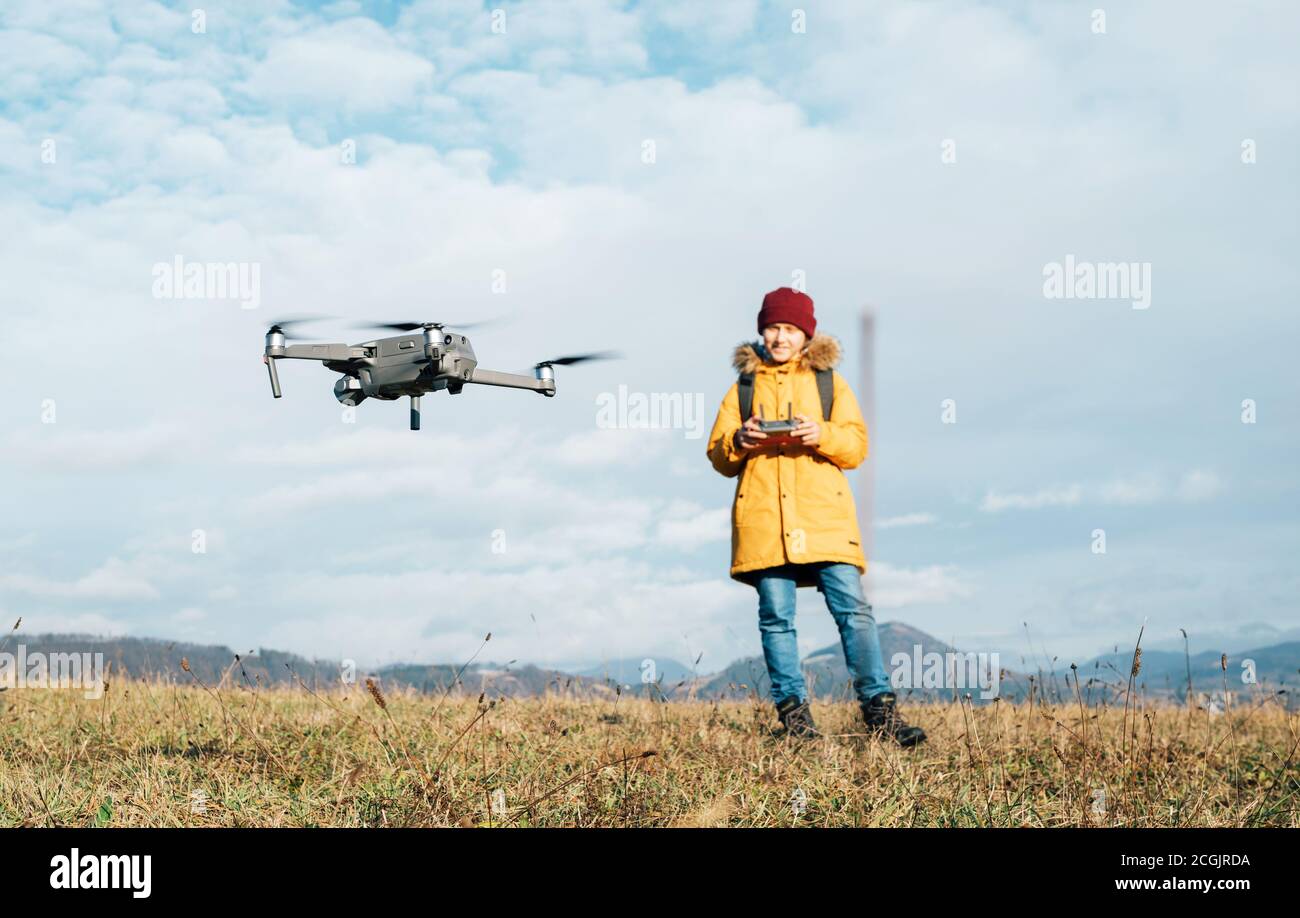 Close up image of the flying drone with Teenager boy dressed yellow ...