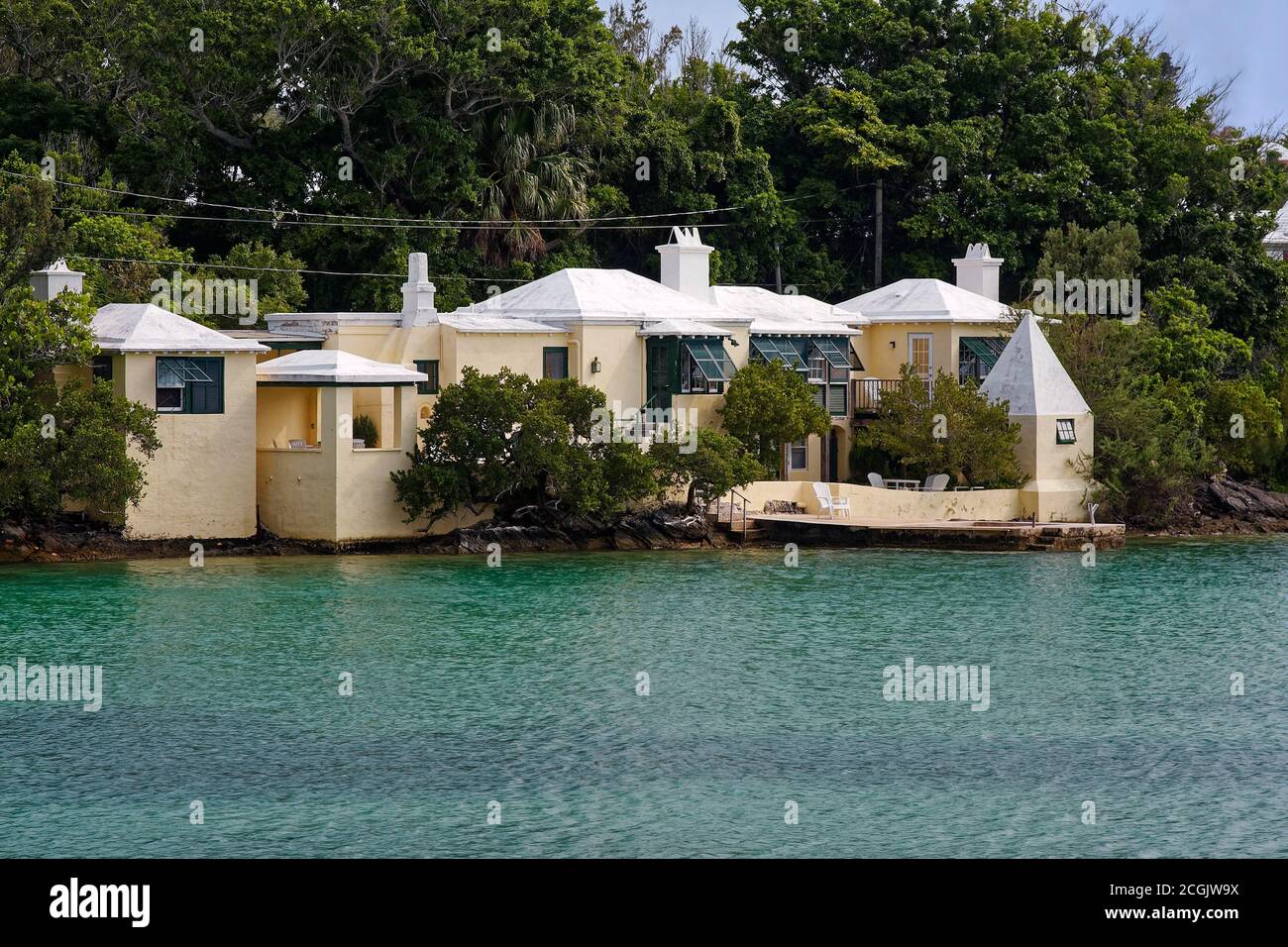 pale yellow house, waterfront, patios, concrete dock, chairs, chimneys ...