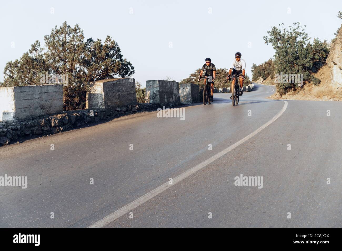 Two professional male cyclists riding their racing bicycles in the ...