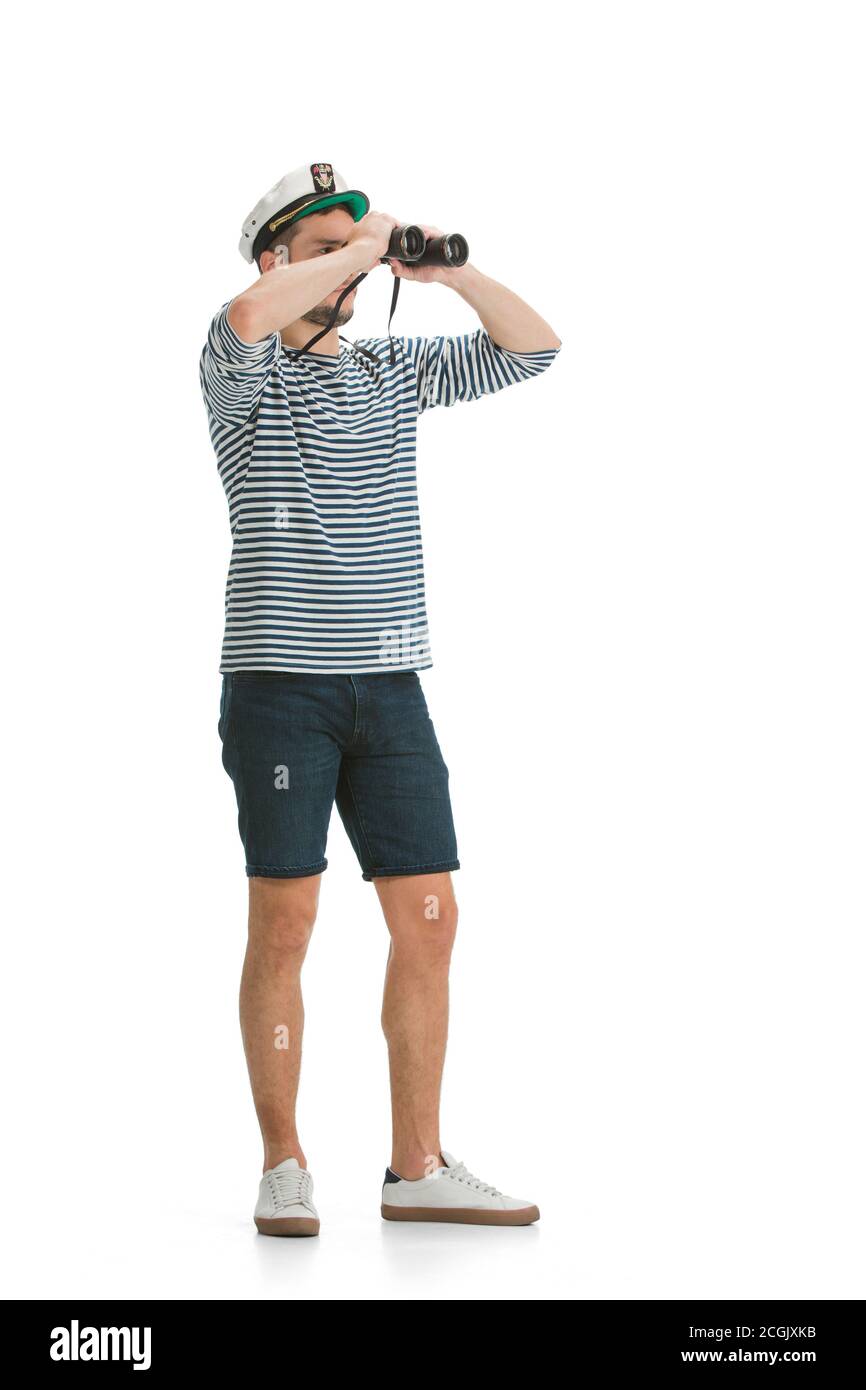 Holding binocular. Caucasian male sailor in uniform on white studio ...