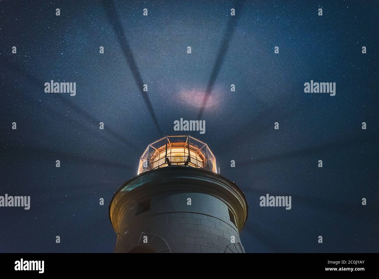 White sea lighthouse in Feodosia, Crimea on the Black Sea with rays of ...