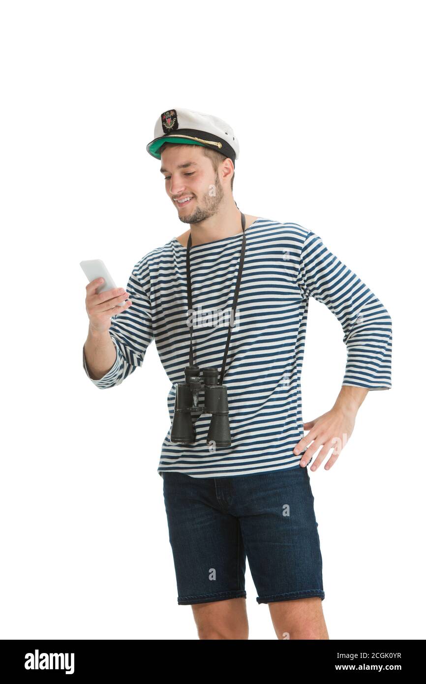 Scrolling phone. Caucasian male sailor in uniform on white studio ...