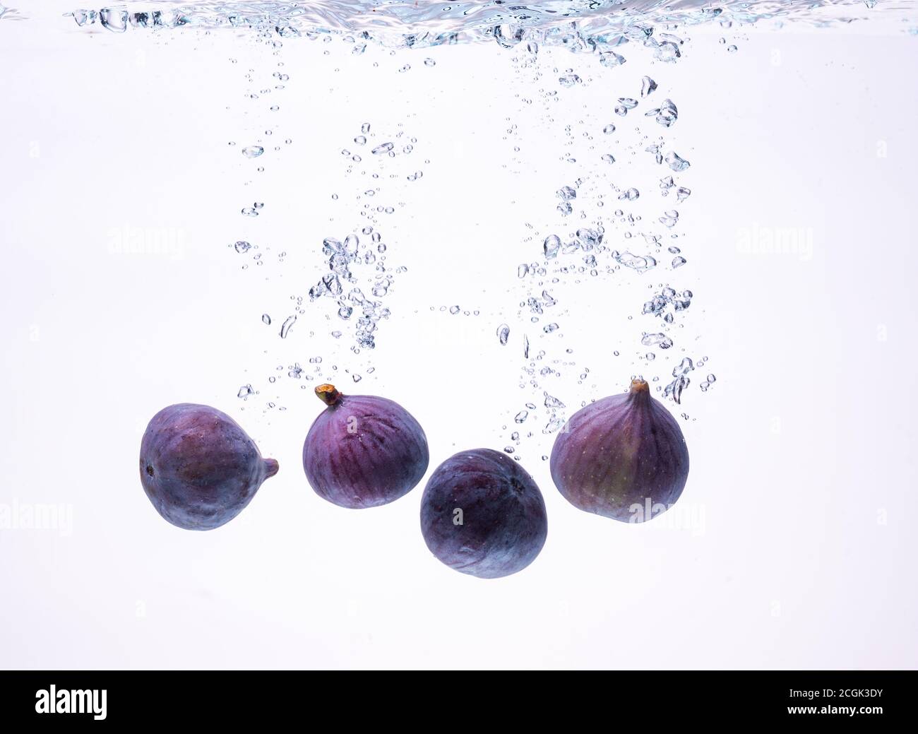 Fresh figs falling into the water isolated on white background. Food ...
