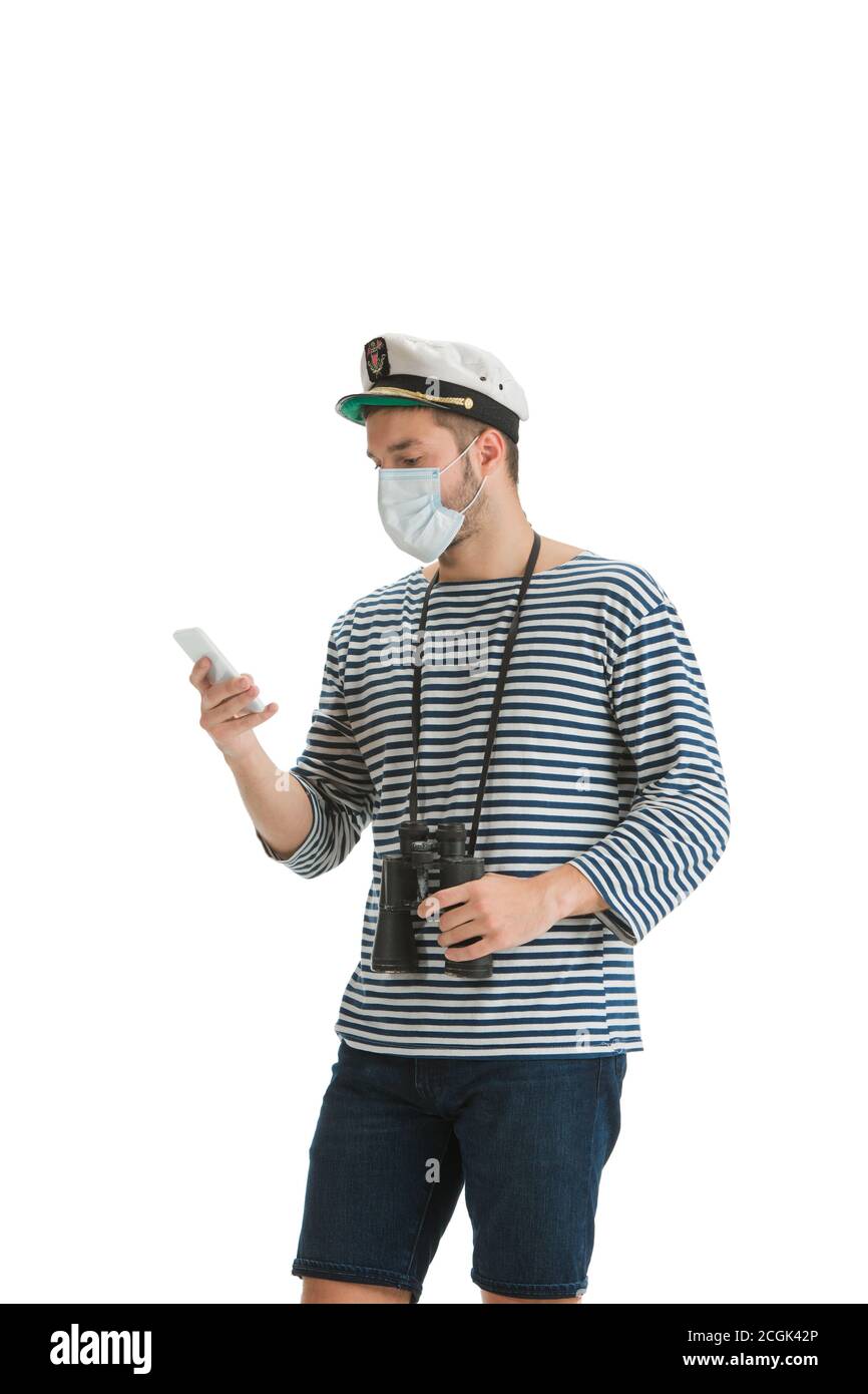 Scrolling phone. Caucasian male sailor in uniform on white studio ...