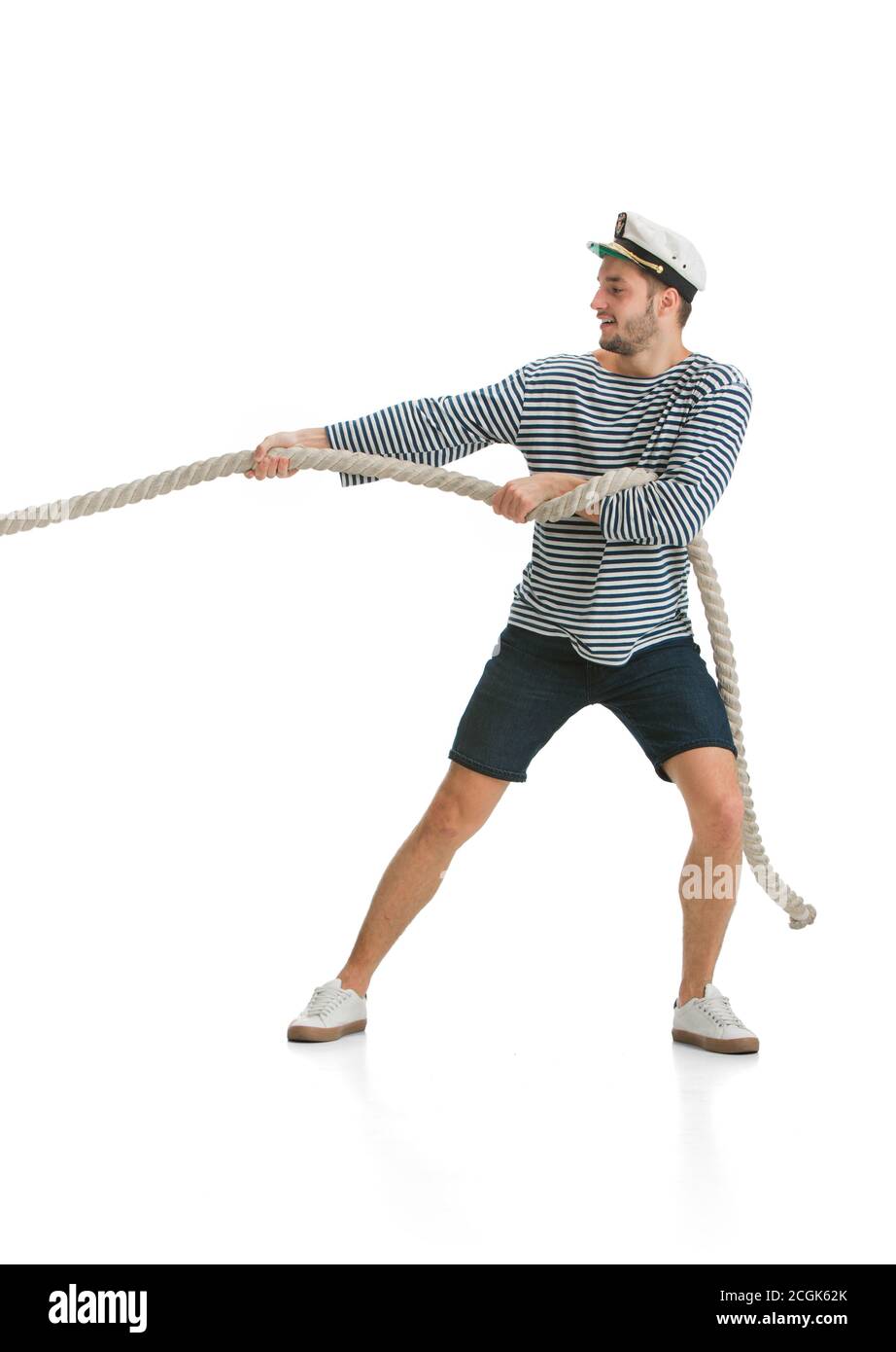 Pulls the rope, tug of war. Caucasian male sailor in uniform on white ...